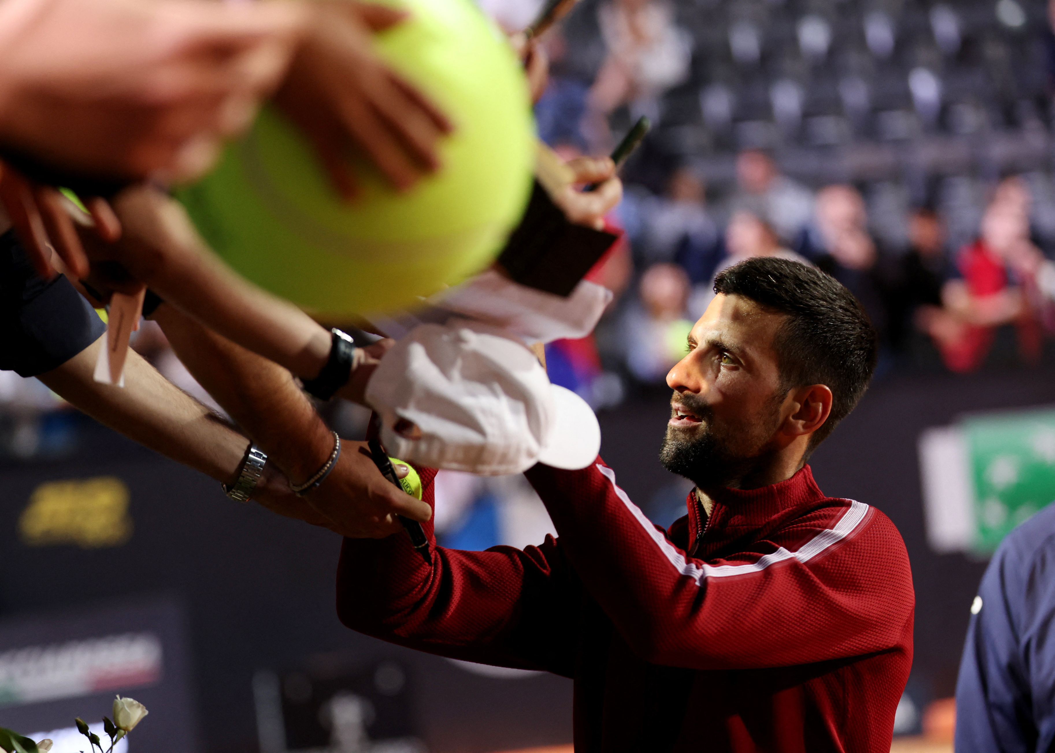 Djokovic struck on the head by water bottle while signing autographs ...