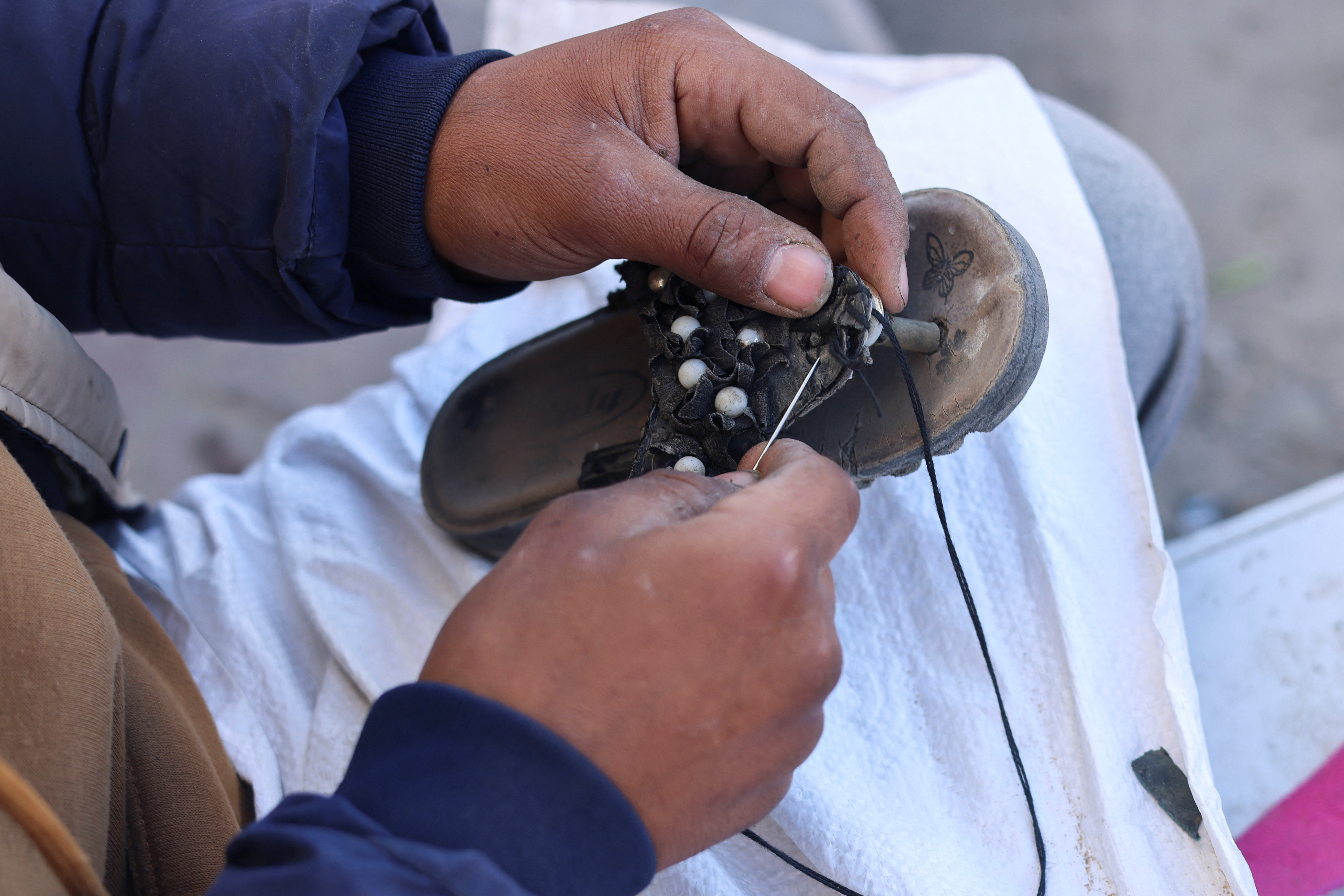 Gaza cobblers work by roadsides to mend shoes of displaced | Reuters